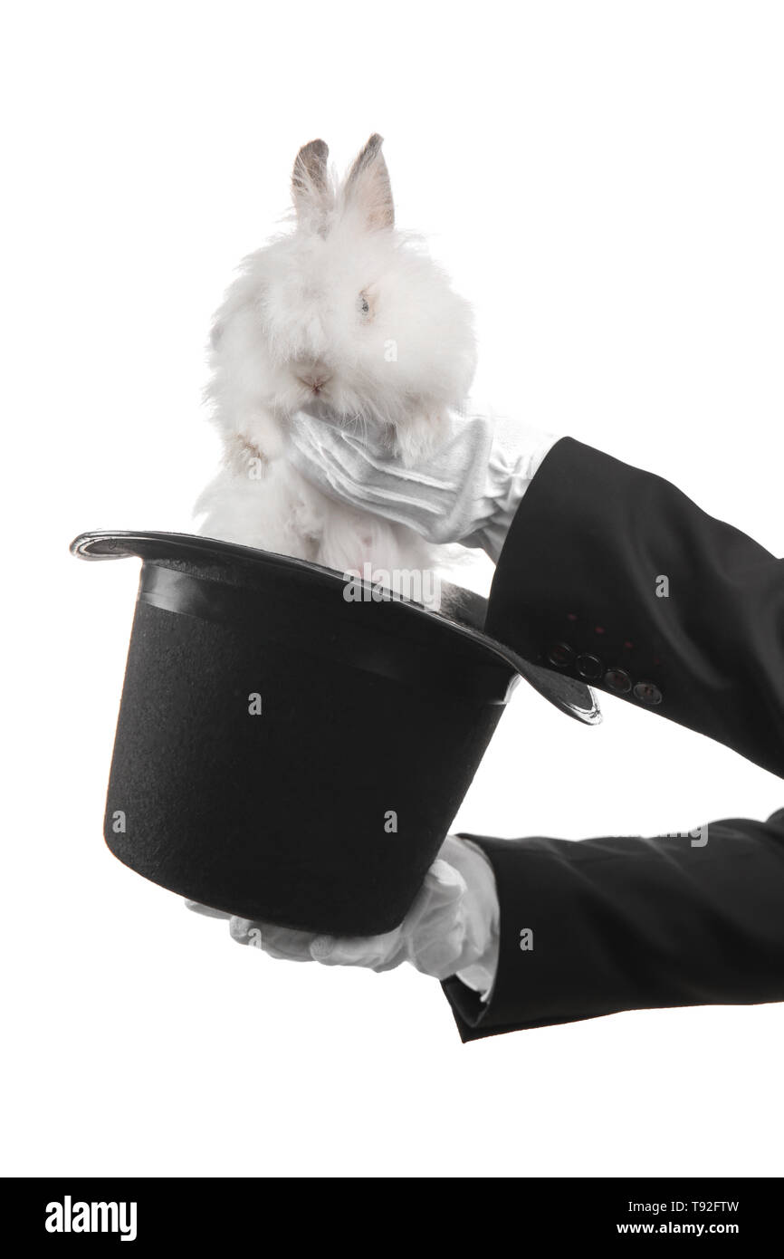Magician holding hat with rabbit on white background Stock Photo - Alamy