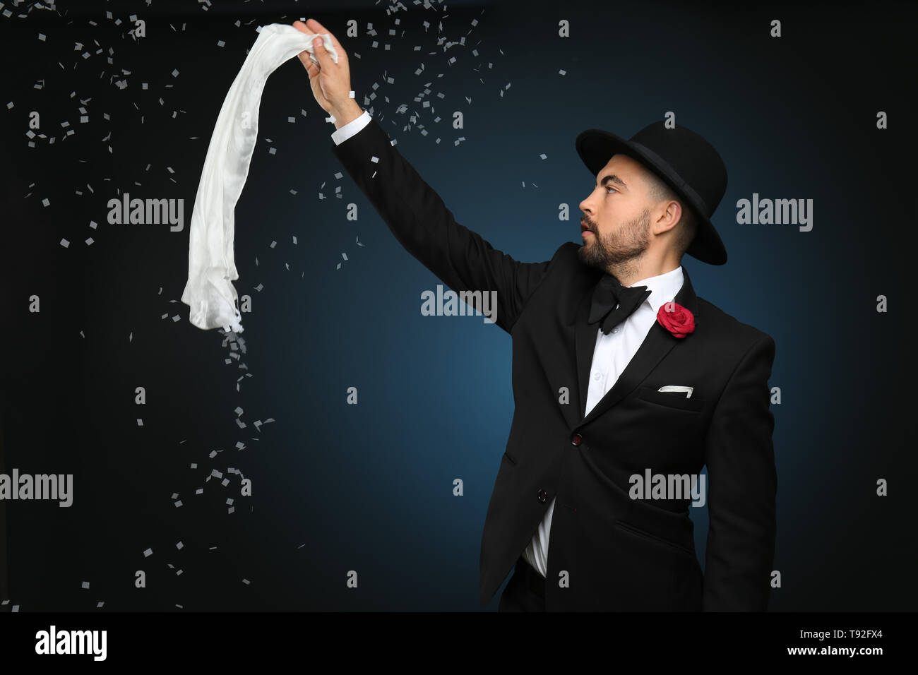 Male magician showing tricks on dark background Stock Photo - Alamy