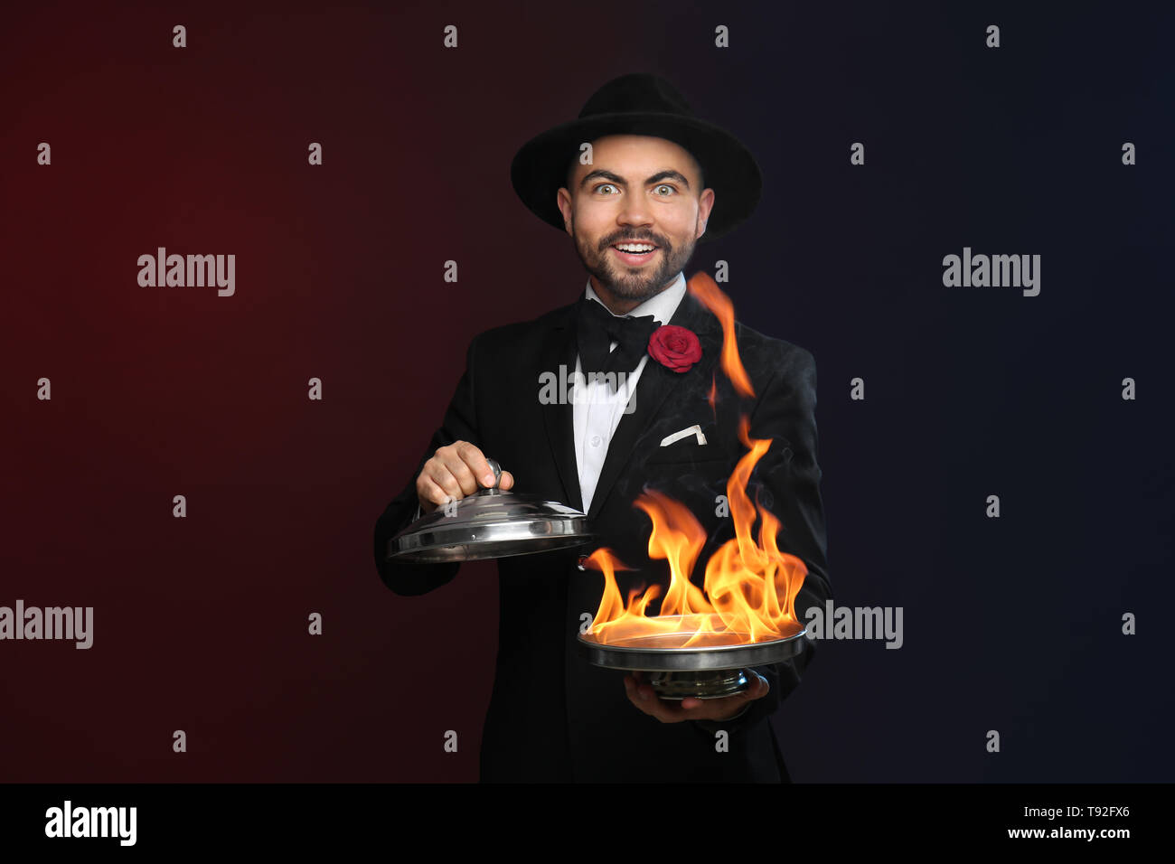 Male magician showing tricks on dark background Stock Photo - Alamy