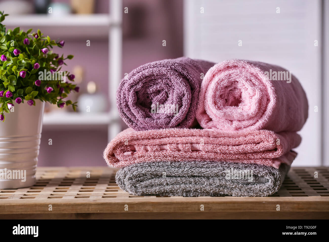 Clean soft towels on table in bathroom Stock Photo - Alamy