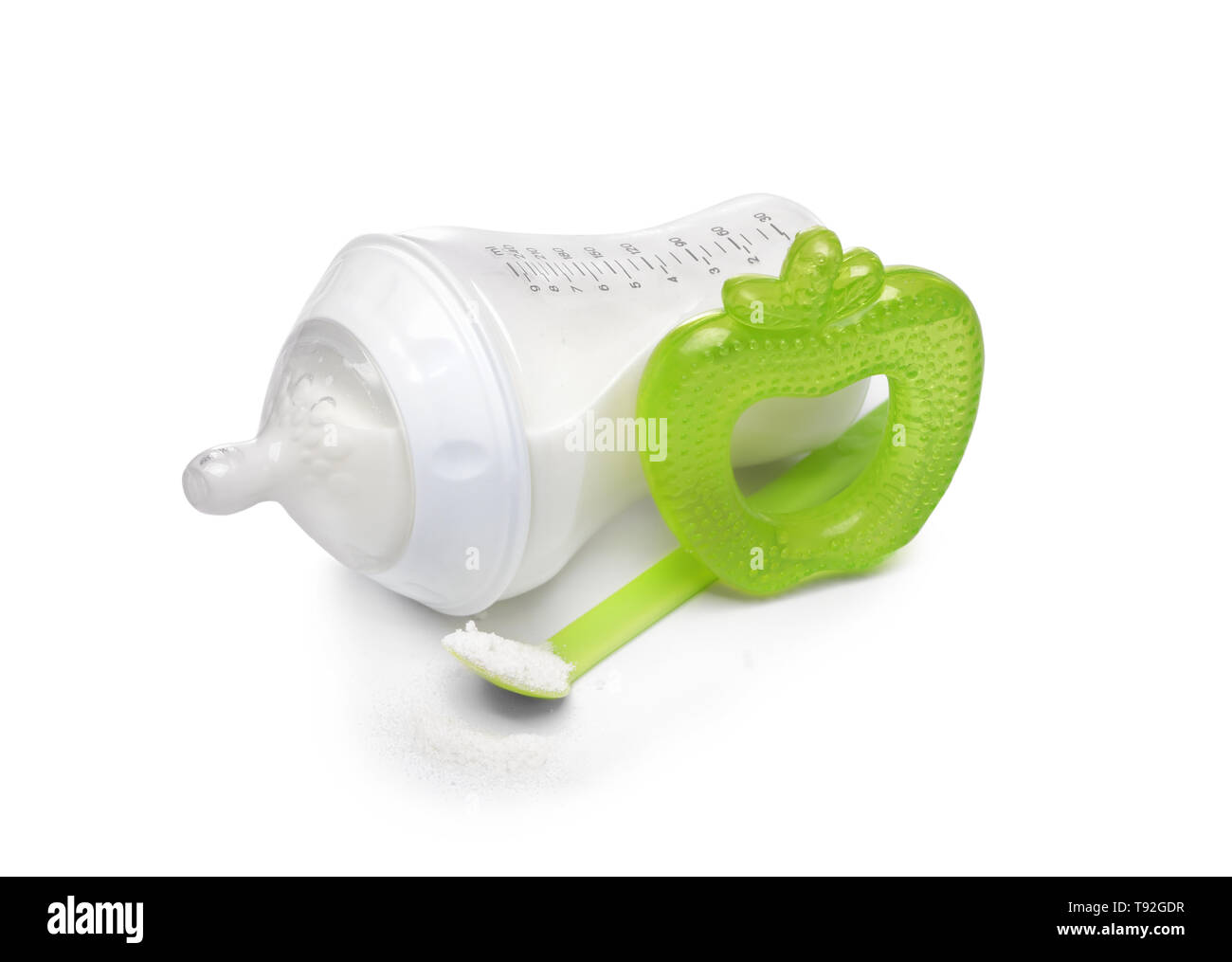 Feeding bottle of baby formula, teether and spoon with powder on white ...