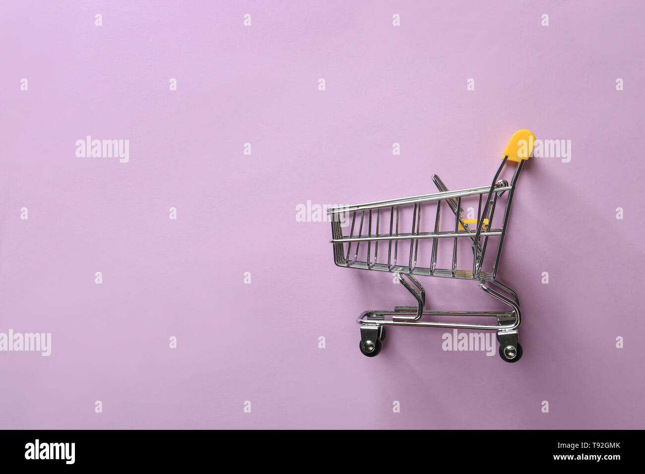 Empty shopping cart on color background Stock Photo - Alamy