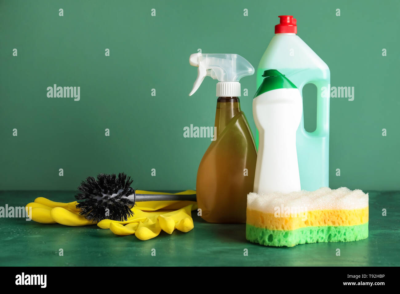 Set of cleaning supplies on color table Stock Photo - Alamy