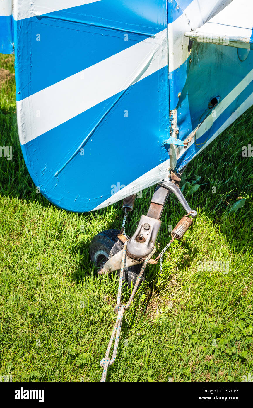 Rear view of tail rudder and wheel of a vintage single engine aircraft ...