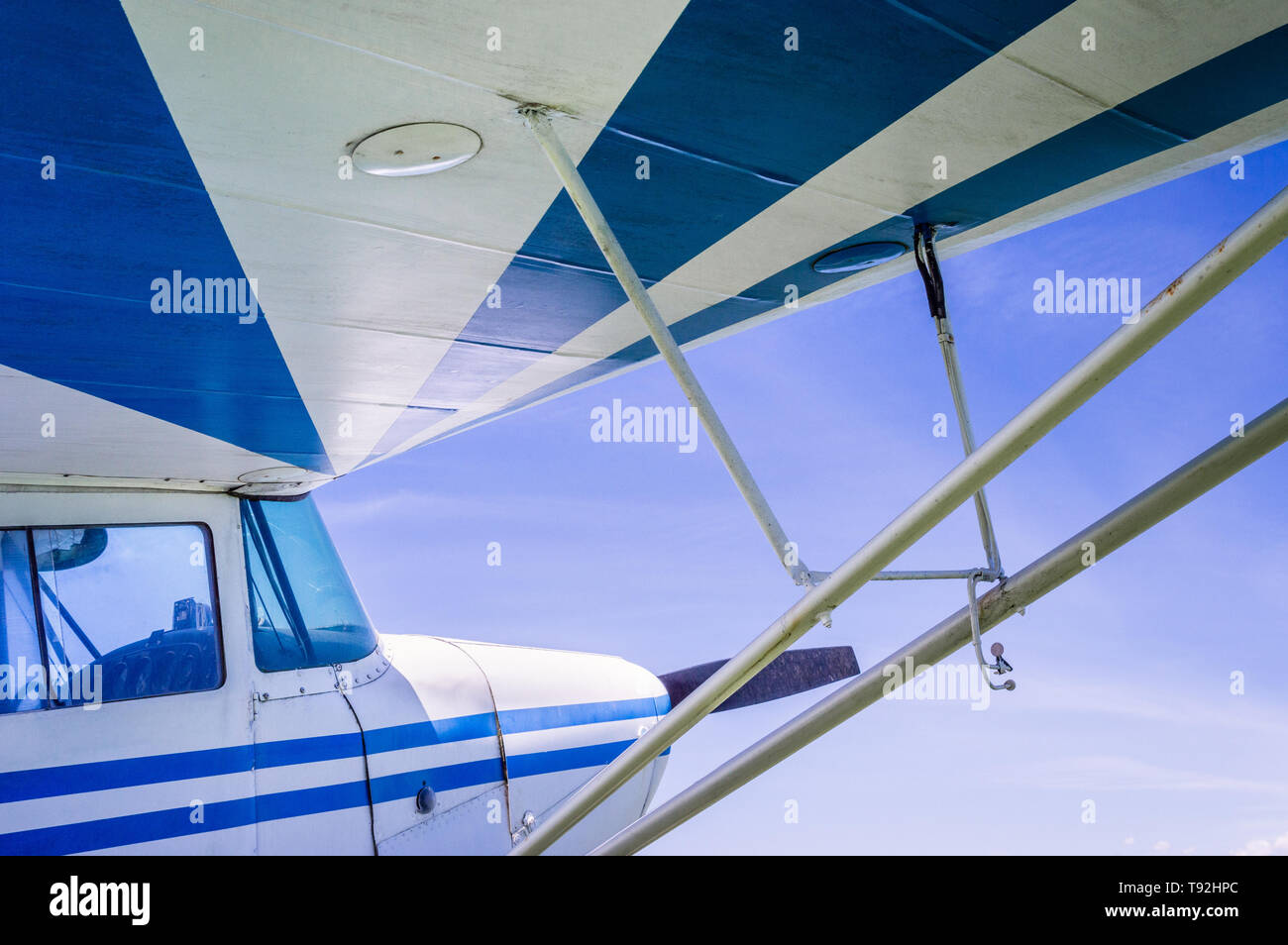 View of cabin from underneath the wing of a blue and white striped ...