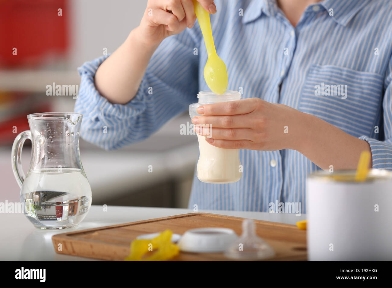 Woman preparing baby formula at table Stock Photo - Alamy