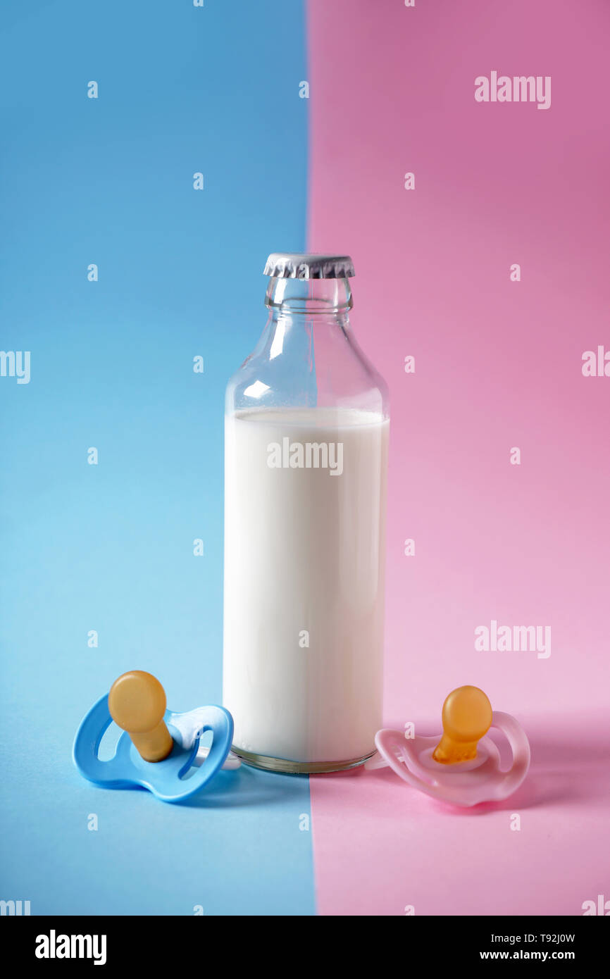 Bottle of milk and pacifiers on color background Stock Photo - Alamy