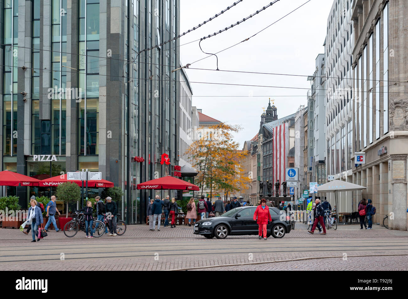 Pedestrians on street alongside with old buildings in central business ...