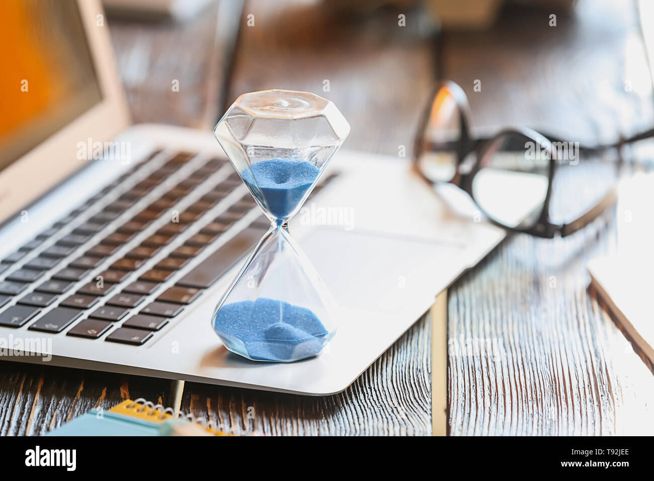 Hourglass on laptop keyboard. Time management concept Stock Photo - Alamy