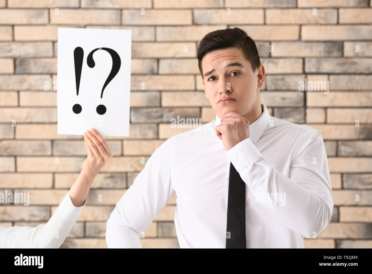 Thoughtful young businessman and female hand holding paper sheet with ...