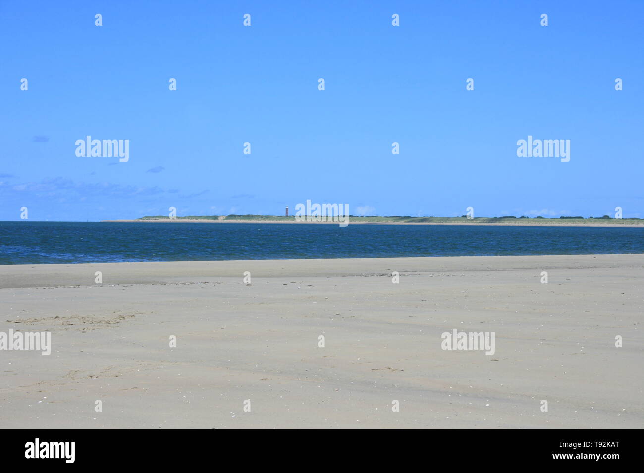 Sandy beach with sea and blue sky background Stock Photo - Alamy