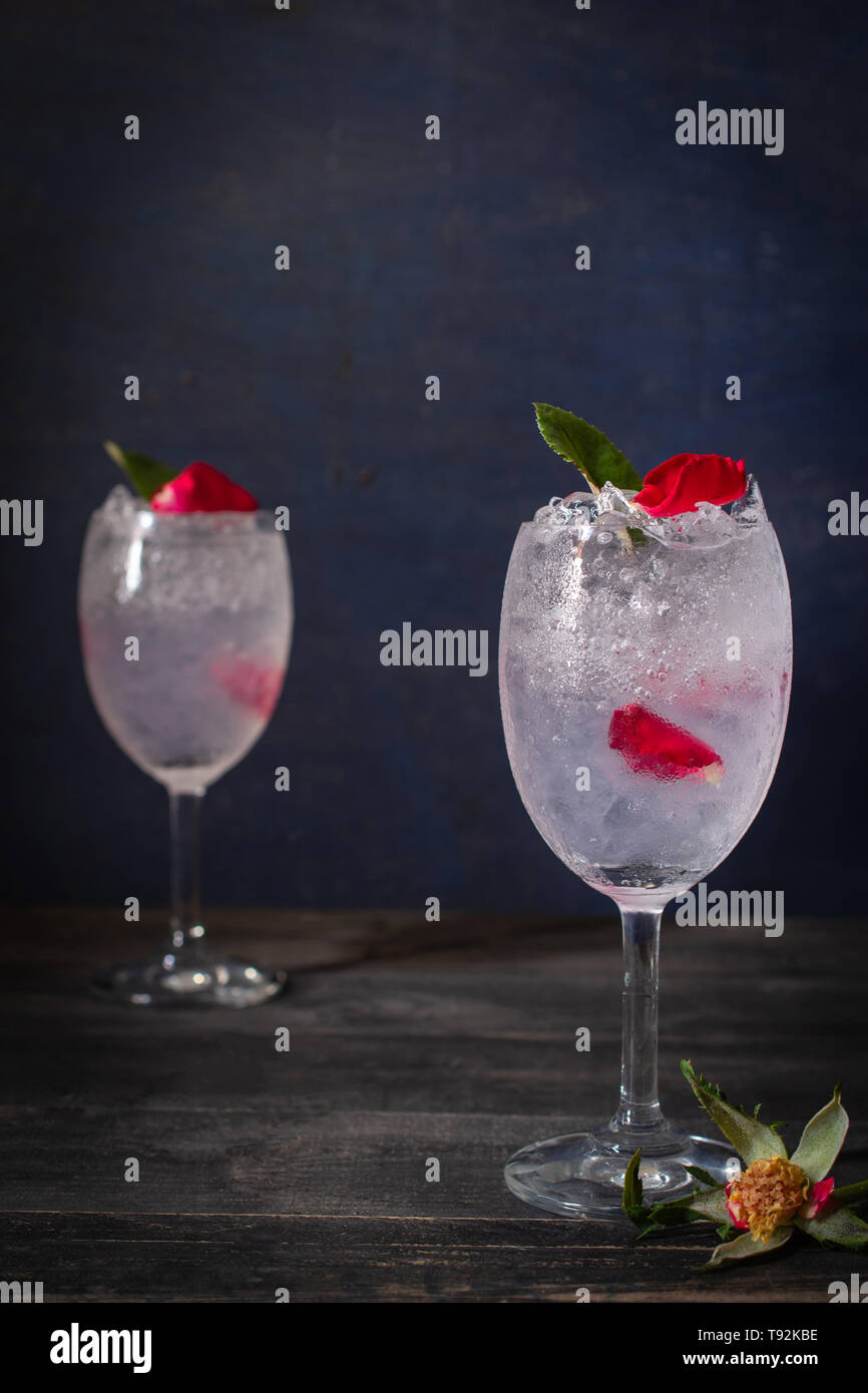 Sparkling cold water detox with rose and ice on the wood table there is ...