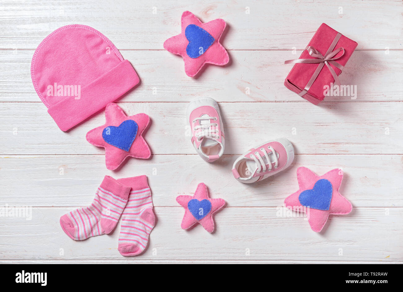 Set of baby clothes and accessories on white wooden background, flat ...