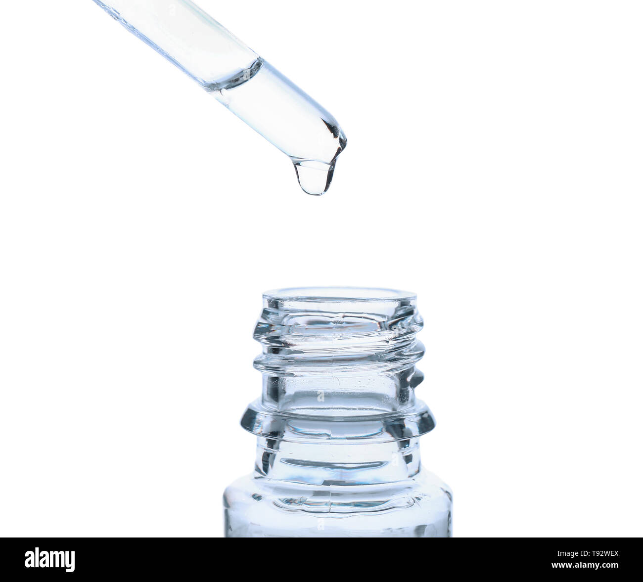 Liquid dripping from pipette into glass bottle on white background ...
