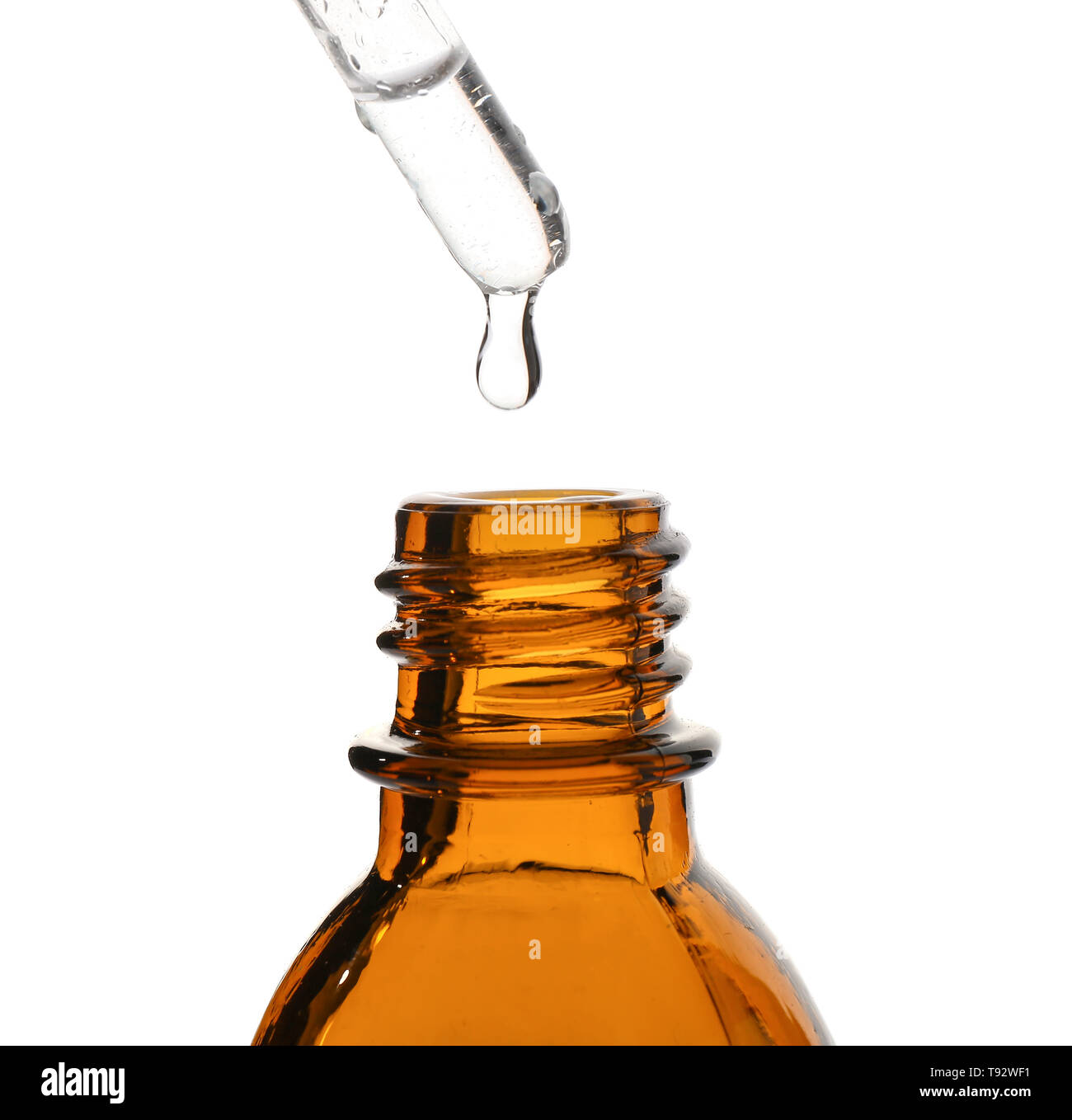 Liquid dripping from pipette into glass bottle on white background ...