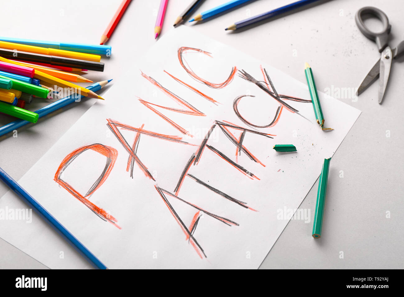 Paper with text PANIC ATTACK and colorful pencils on white background ...