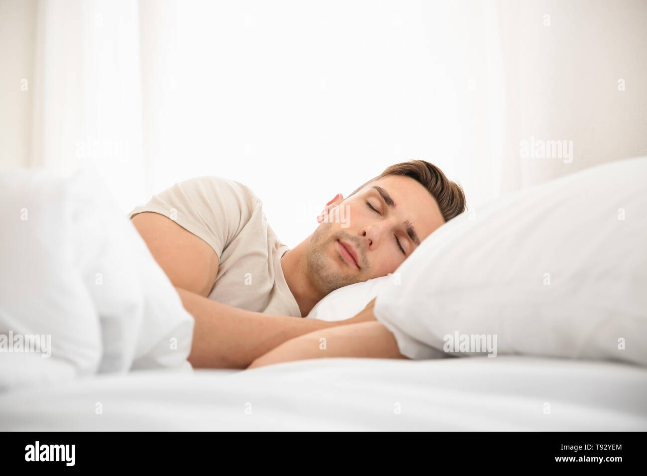 Handsome man sleeping in bed hi-res stock photography and images - Alamy