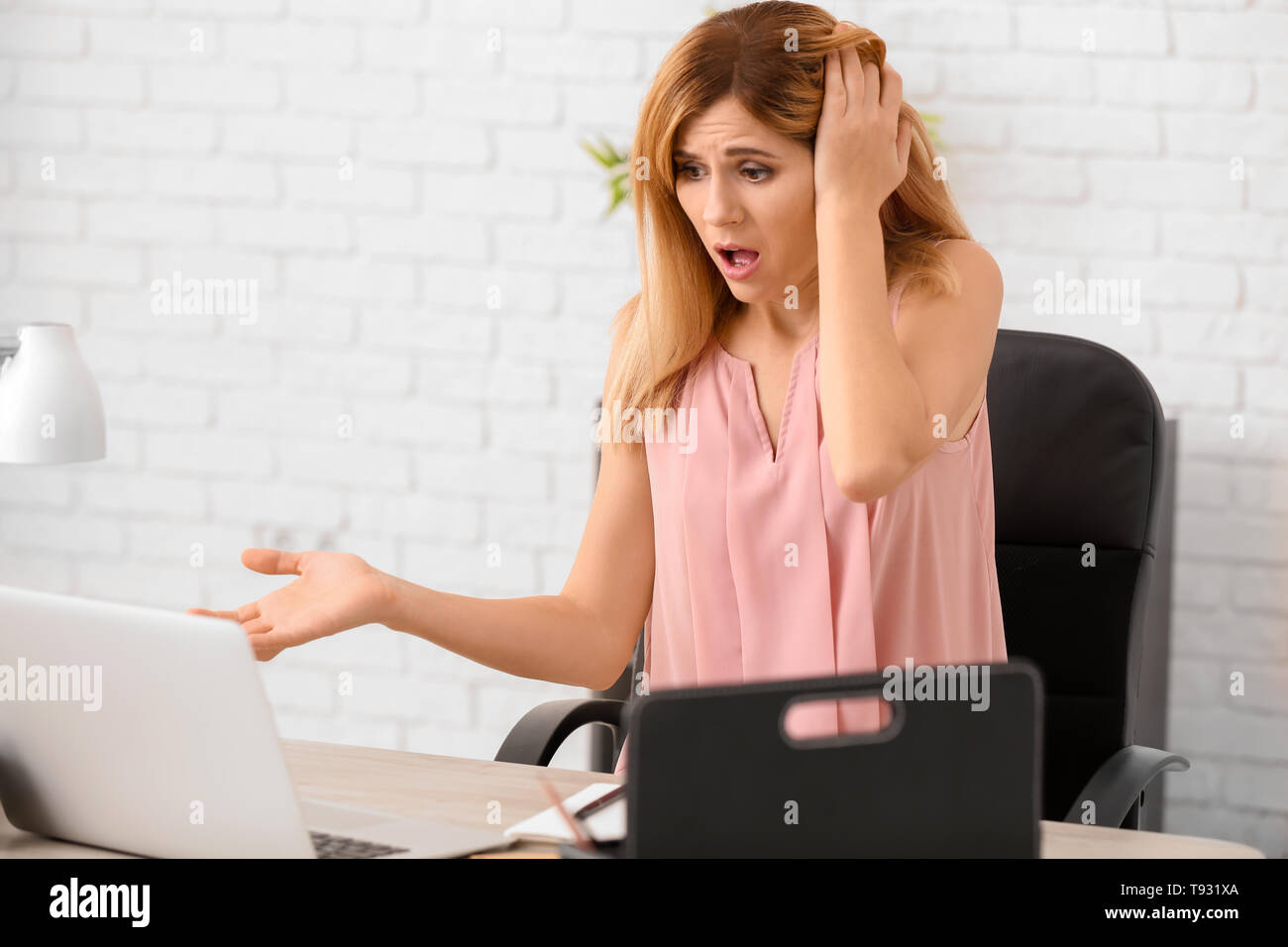 Stressed woman with laptop at workplace Stock Photo - Alamy