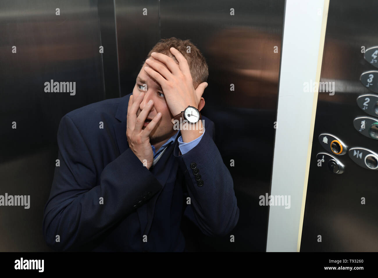 Businessman having panic attack in elevator Stock Photo - Alamy
