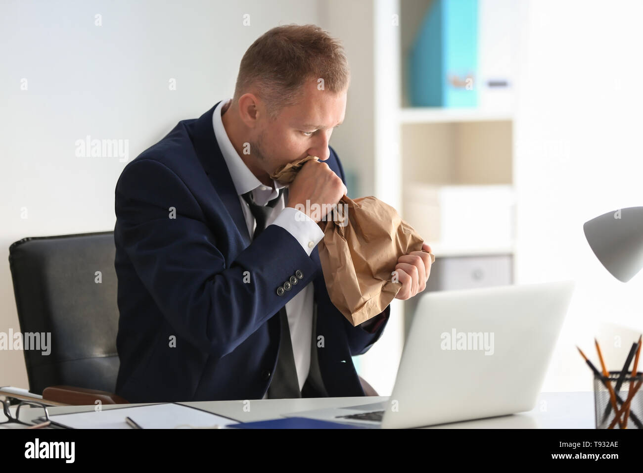 Man having panic attack at workplace in office Stock Photo - Alamy