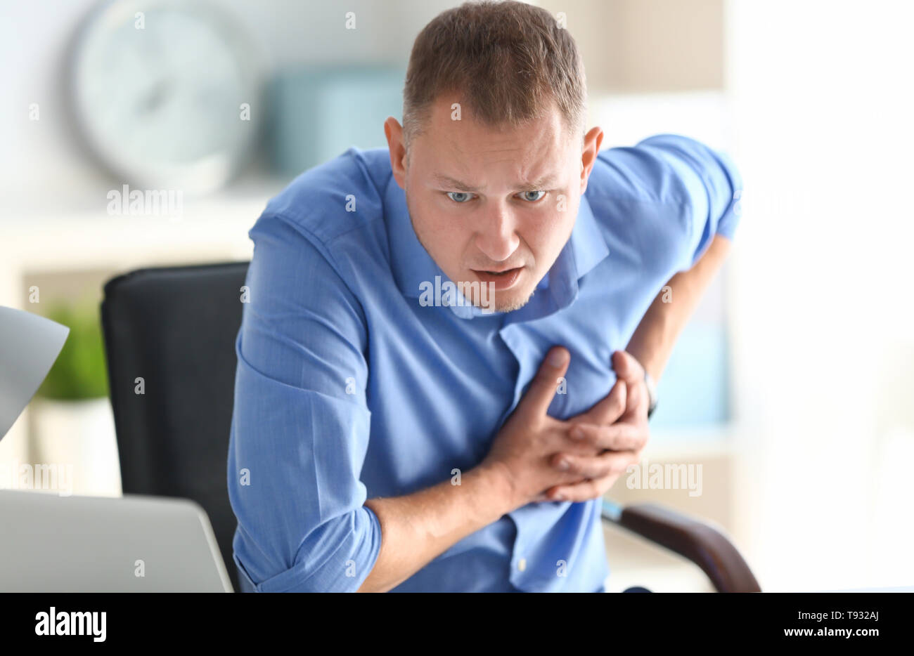 Man having panic attack at workplace in office Stock Photo - Alamy