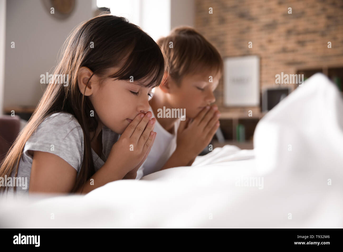 Cute children praying near bed at home Stock Photo - Alamy