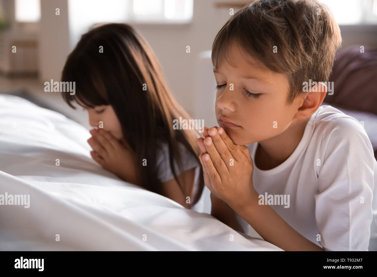 Cute children praying near bed at home Stock Photo - Alamy