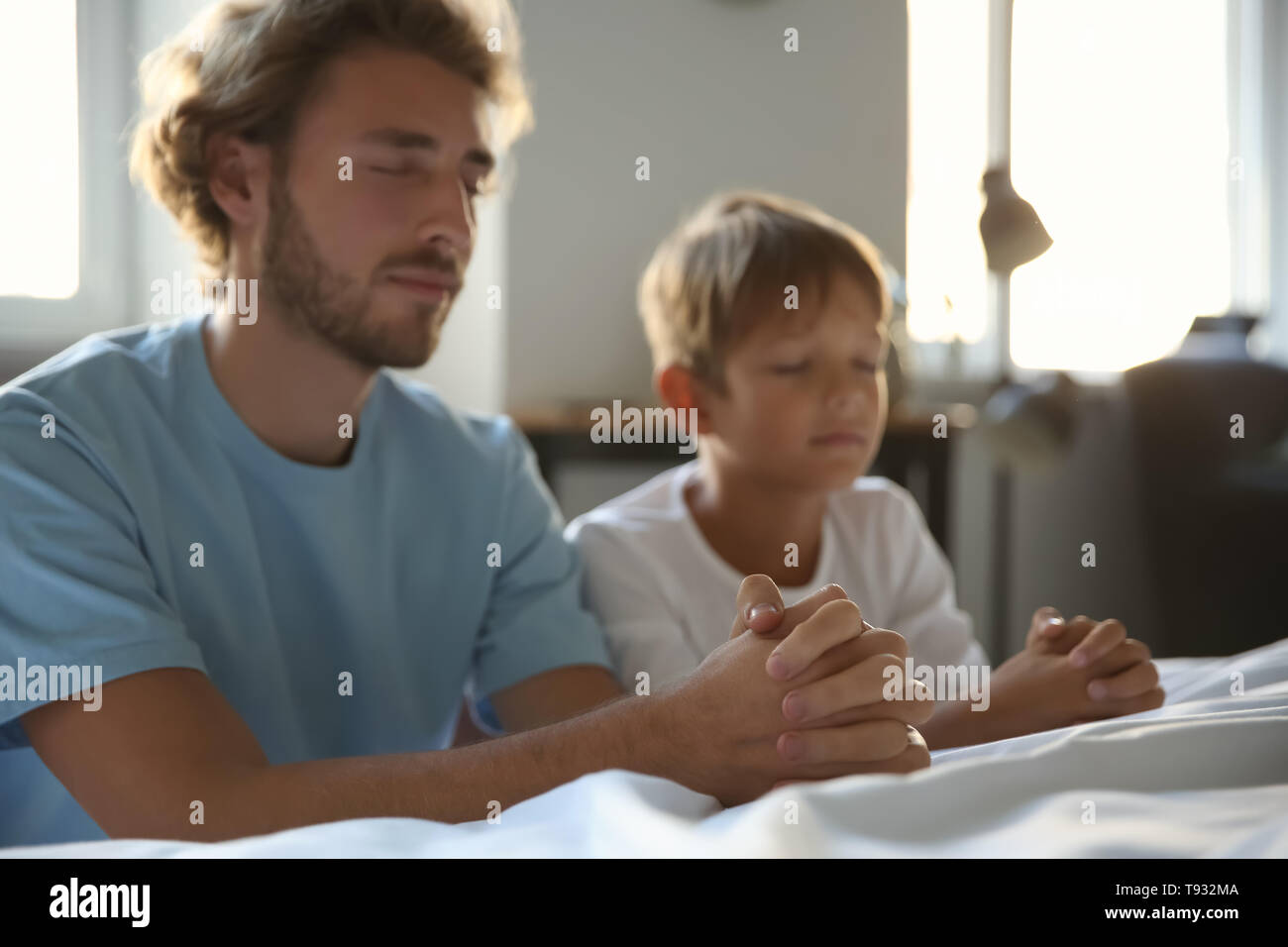 Father with son praying near bed at home Stock Photo - Alamy