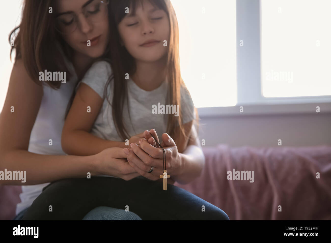 Mother with daughter praying at home Stock Photo - Alamy