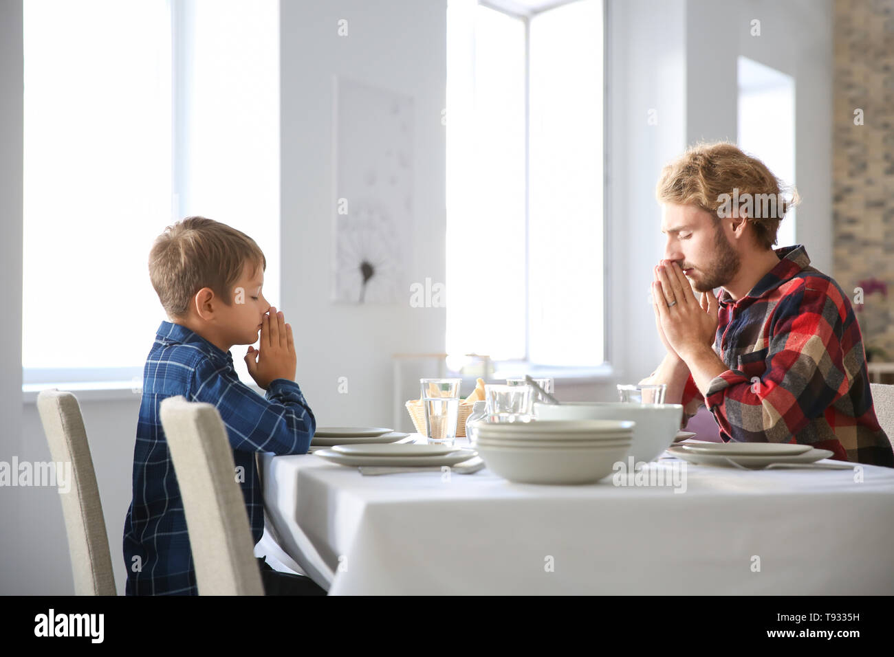 Father with son praying before meal at home Stock Photo - Alamy