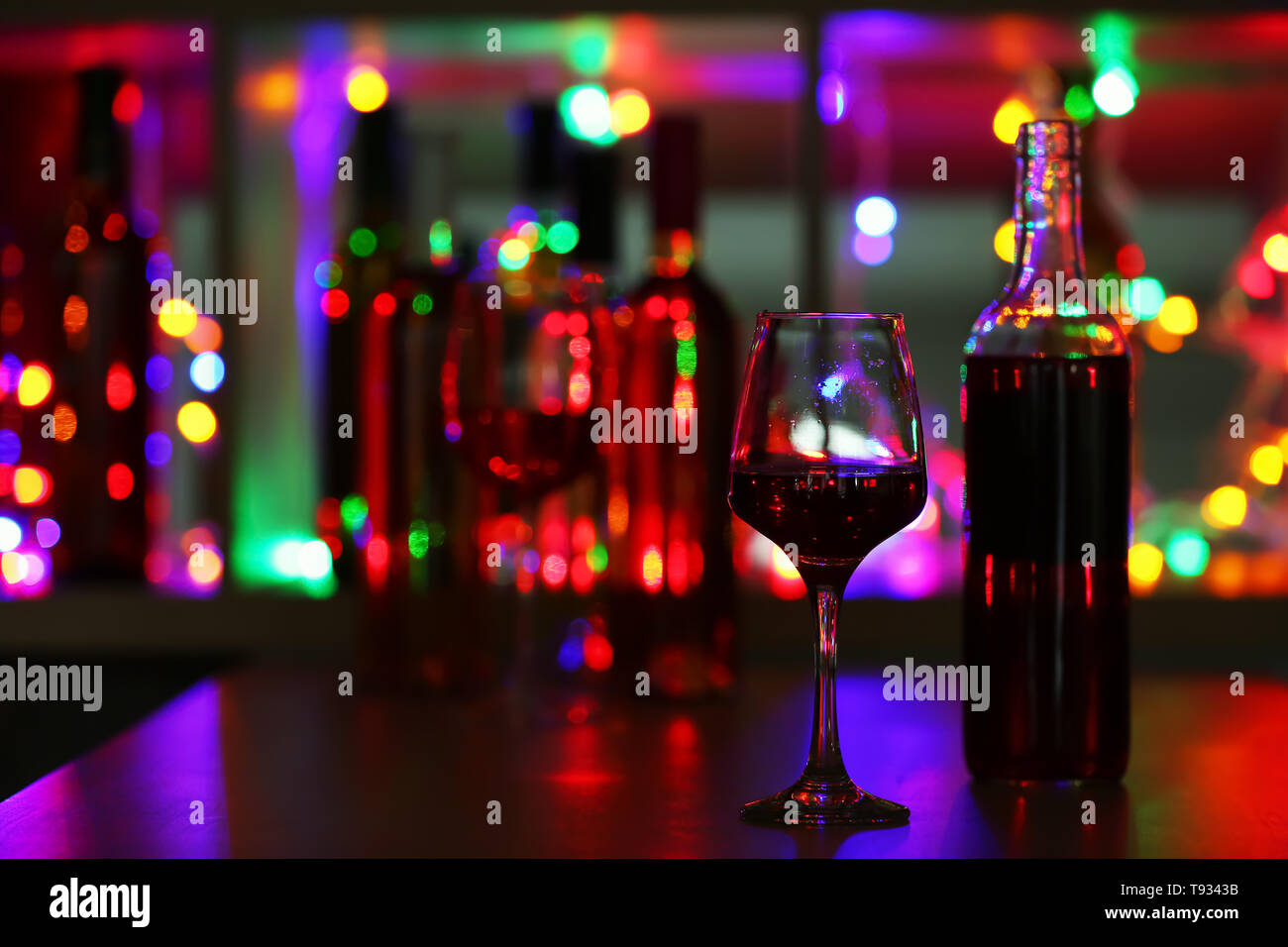 Glass and bottle of wine on bar counter Stock Photo - Alamy