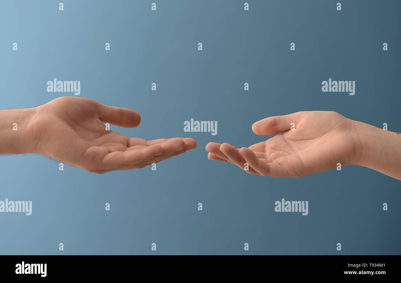 Man and woman giving each other hands on color background. Concept of ...