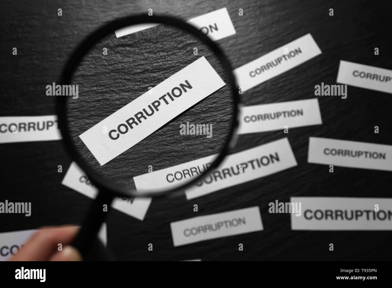 View on pieces of paper with words CORRUPTION through magnifier glass ...