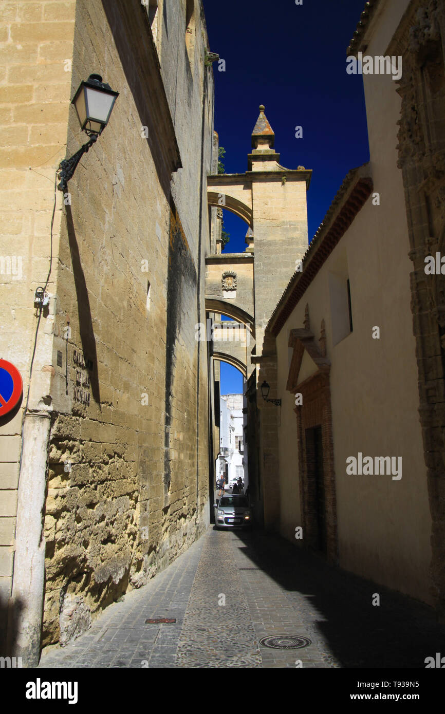 Typical narrow alleyway with arches contrasting with dark blue sky in ...