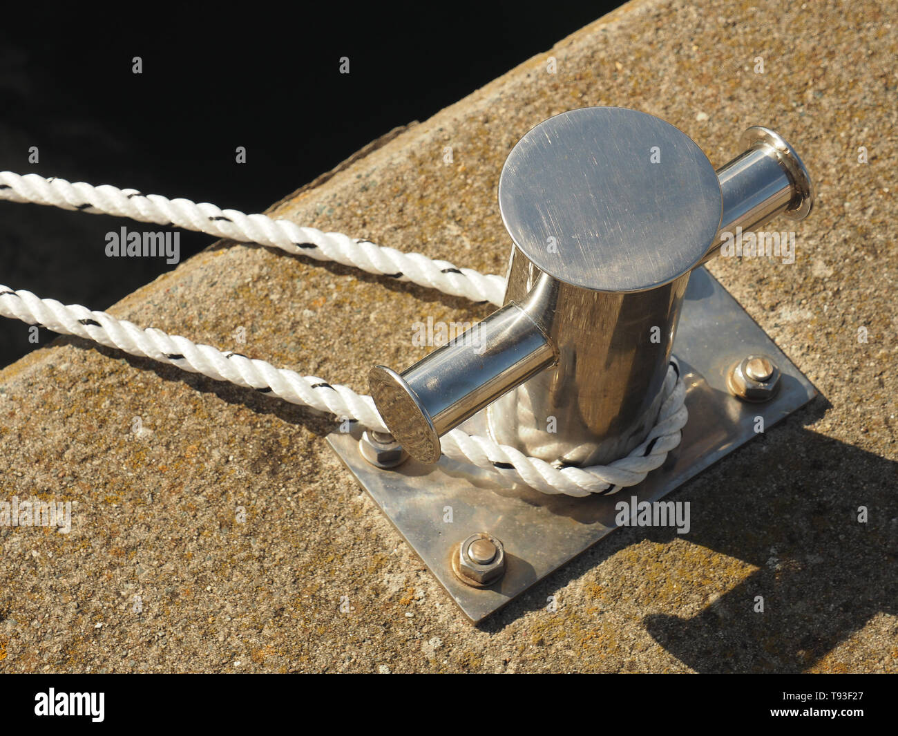 Stainless steel bollard with a rope in a luxury marina Stock Photo - Alamy
