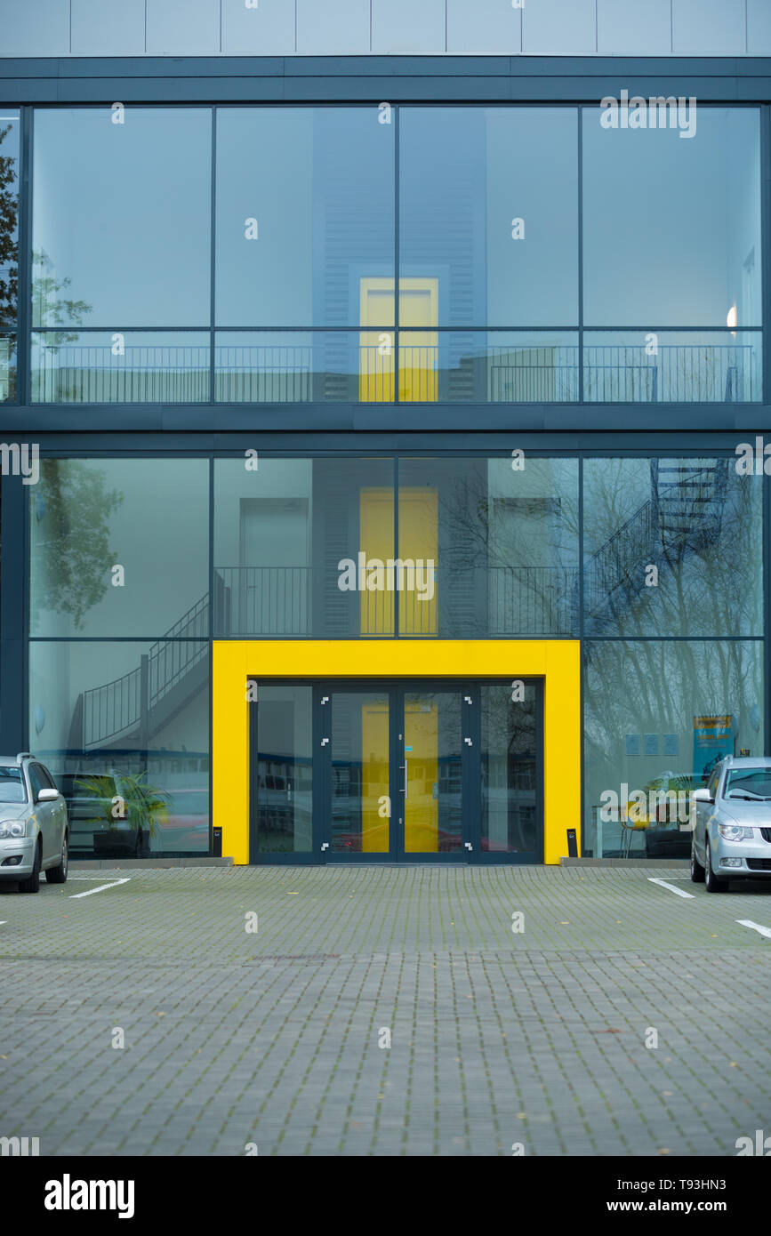 Yellow entrance of a modern glass office building Stock Photo - Alamy