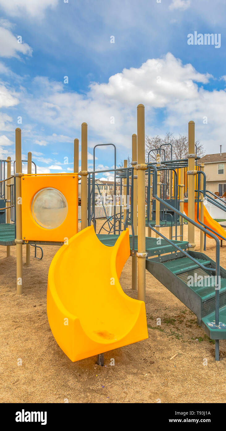 Clear Vertical Playground with a bright yellow slide under the vivid ...