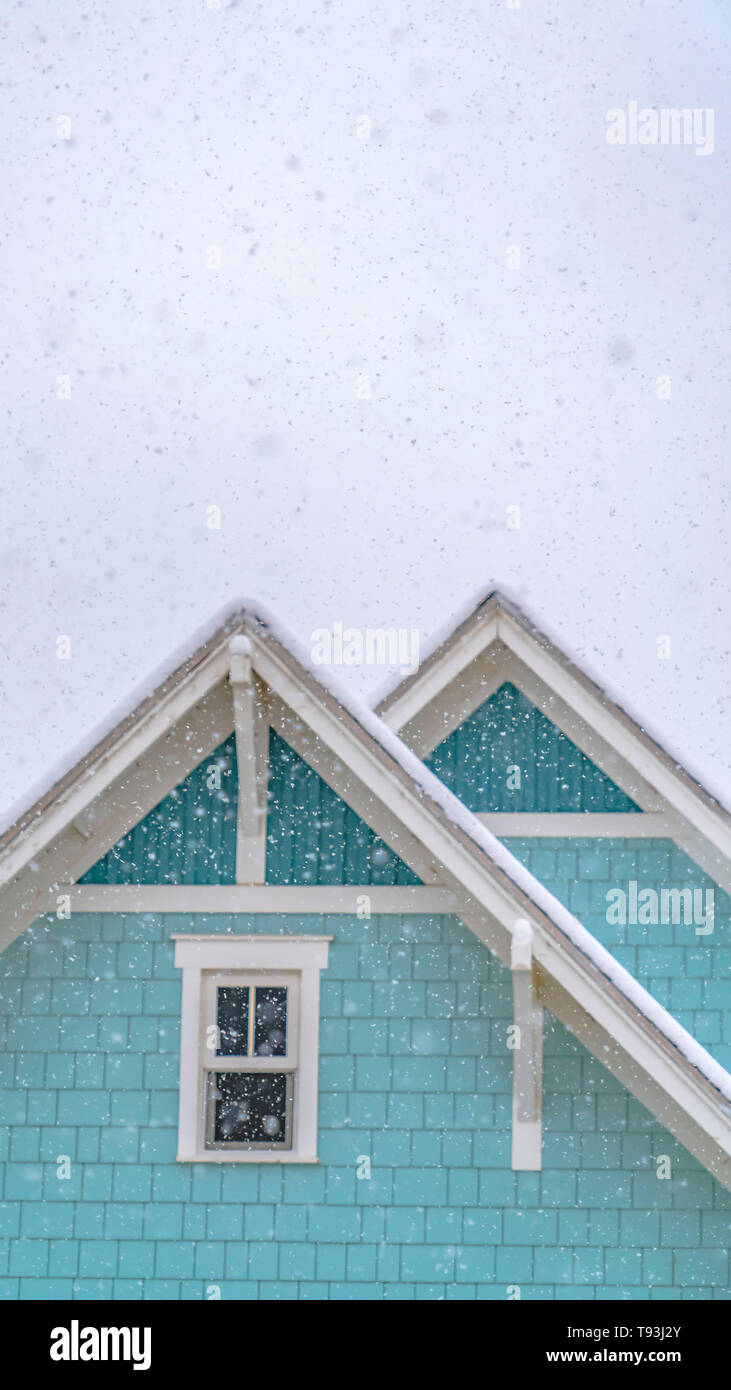 Clear Vertical Vertical Snow falling on a blue home in Daybreak Utah ...