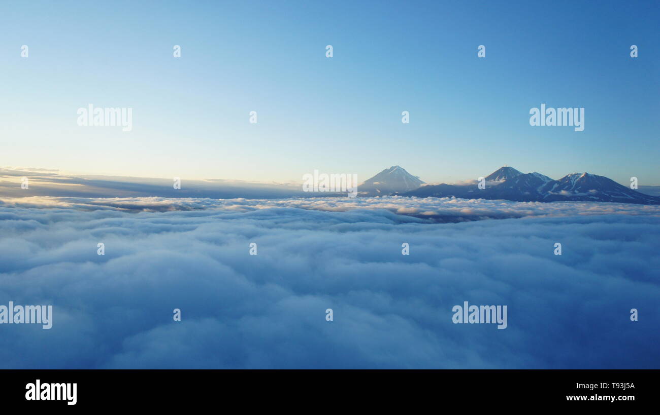 Sunset Photo of Kamchatka volcanoes. High altitude above clouds ...