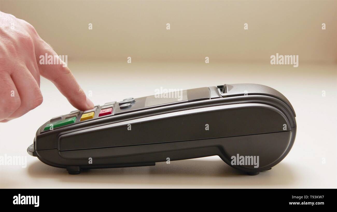 Hand and fingers entering pin with a hand held pin pad Stock Photo - Alamy