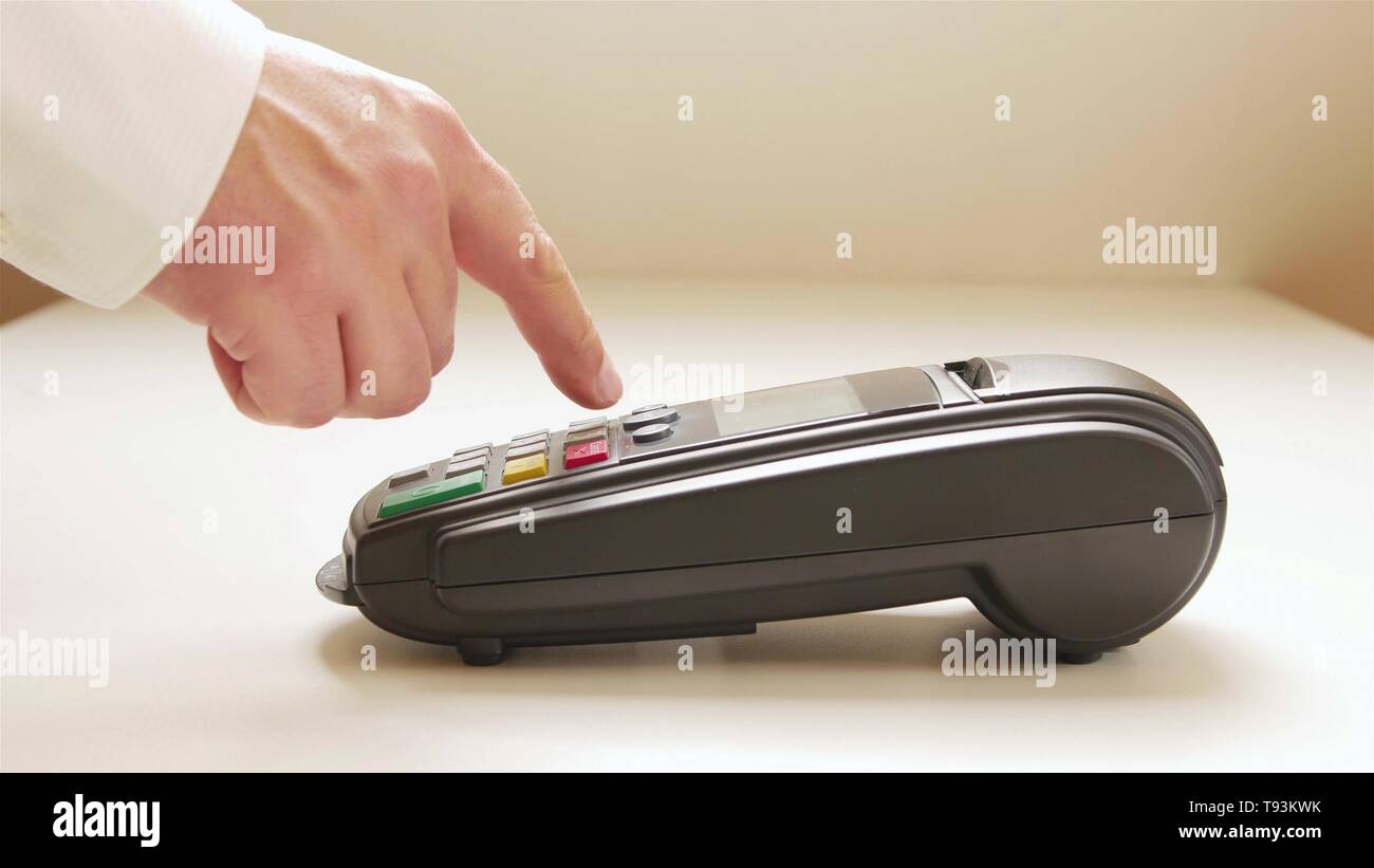 Hand and fingers entering pin with a hand held pin pad Stock Photo - Alamy