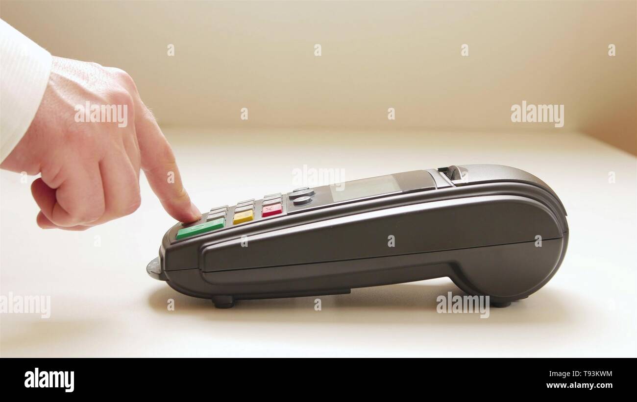 Hand and fingers entering pin with a hand held pin pad Stock Photo - Alamy