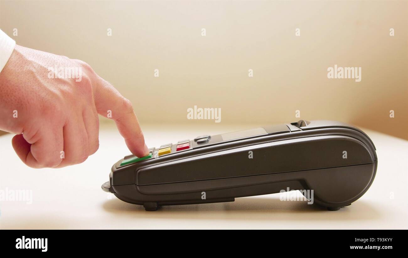 Hand and fingers entering pin with a hand held pin pad Stock Photo - Alamy