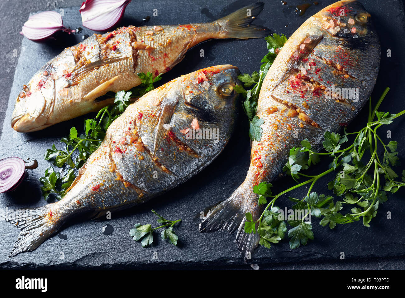 three Raw dorado fish with spices, sea salt, parsley, and red onion ...