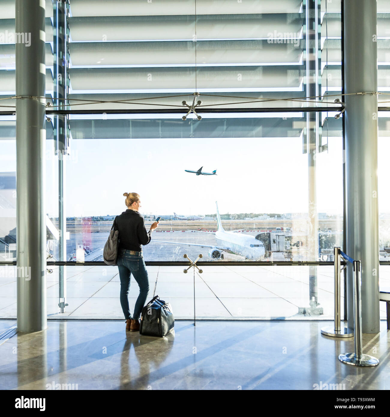 Young woman waiting at airport, looking through the gate window Stock ...