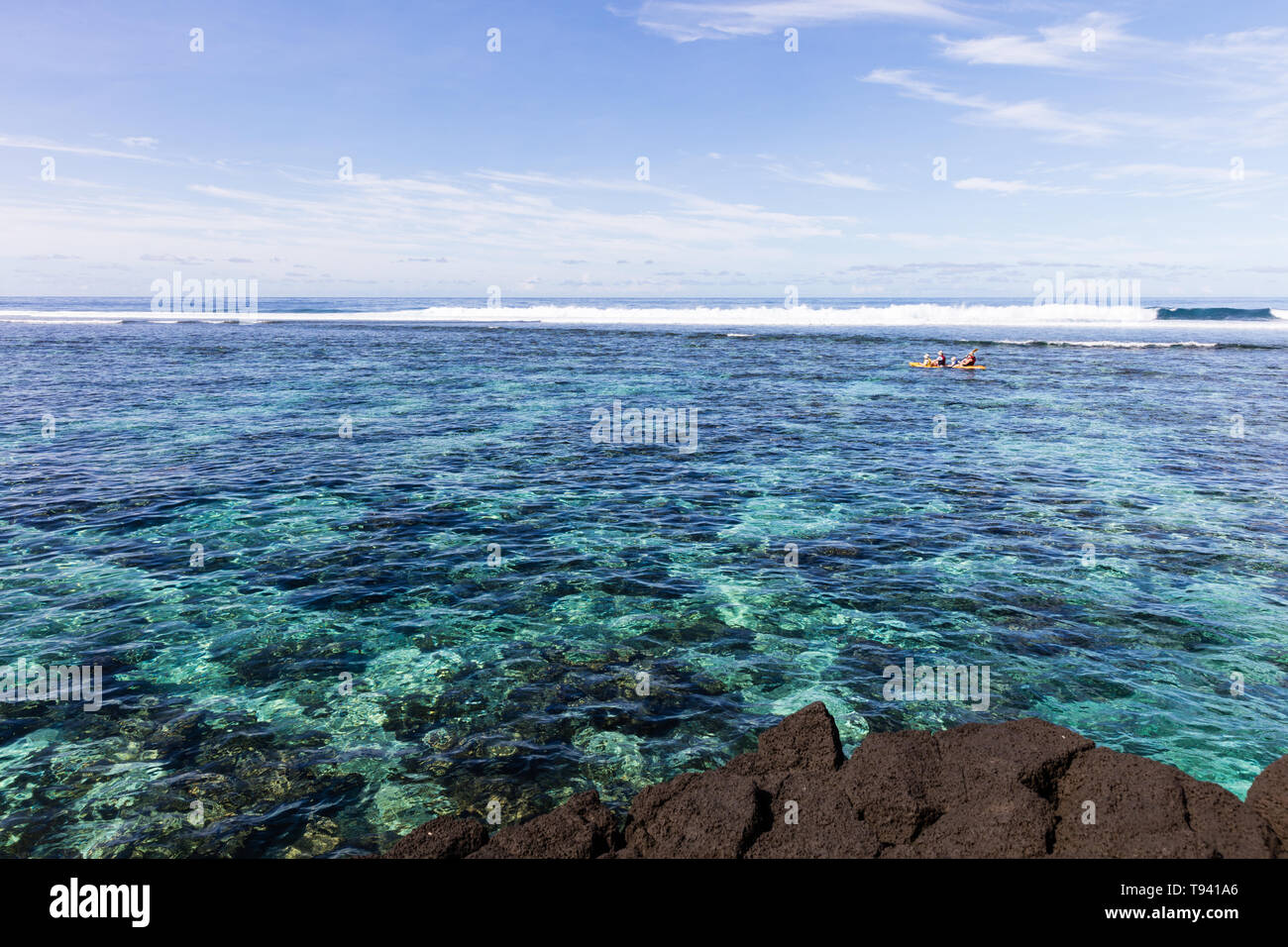 Family doing watersport kayak in clear pacific ocean water in the reef ...