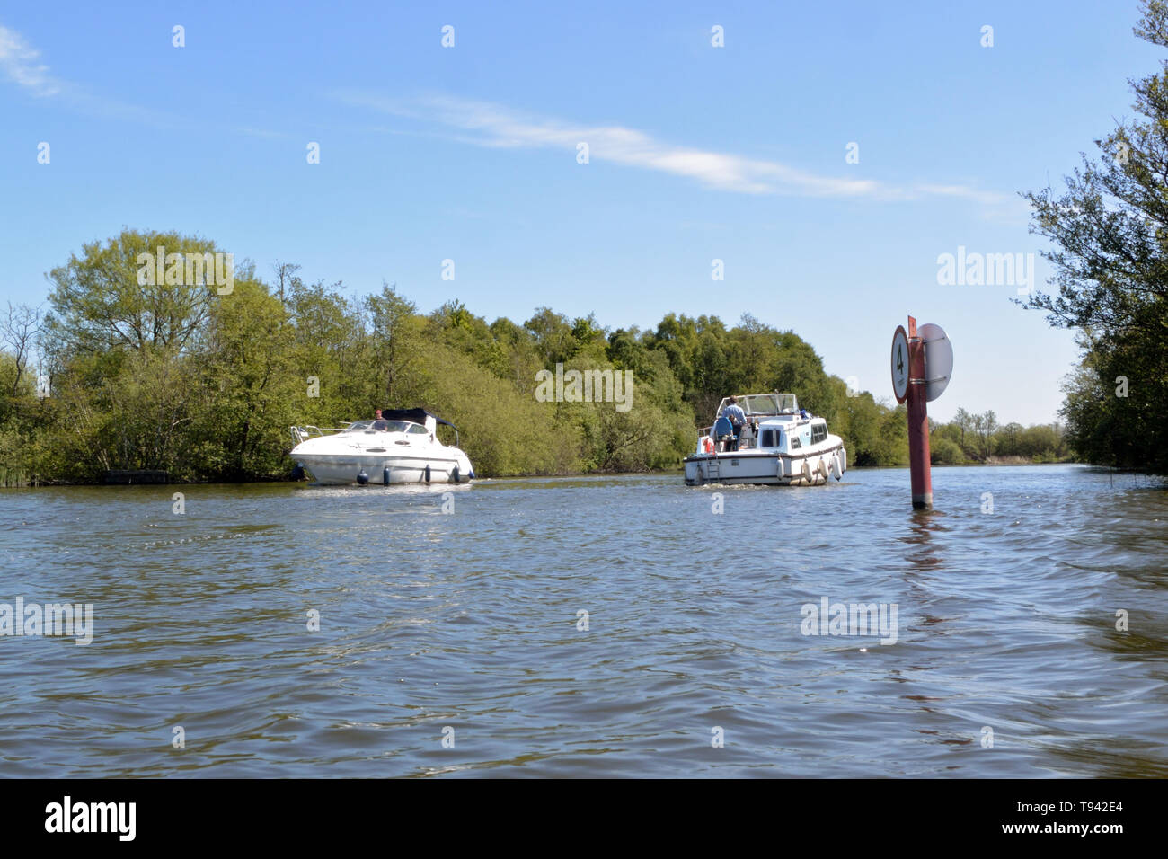 Cabin cruisers pass each other on the River Ant at the southern end of ...