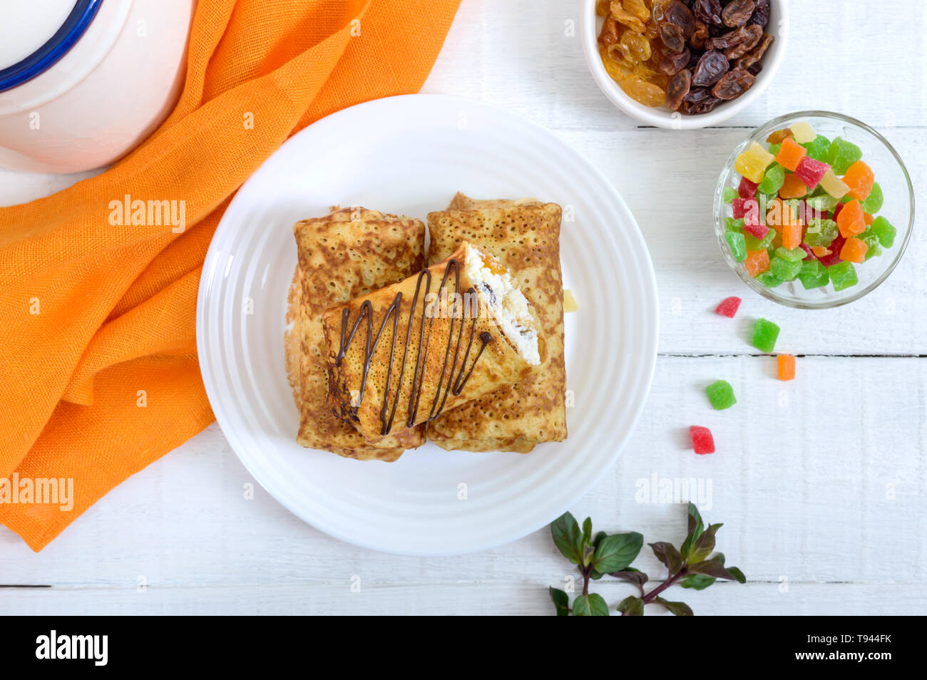 Delicious delicate pancakes with cottage cheese and raisins on a white ...