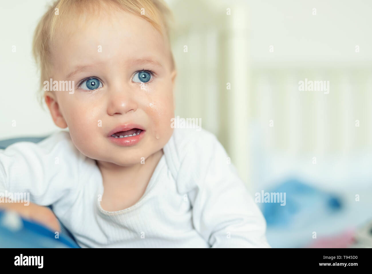 Cute caucasian blond toddler boy portrait crying at home during ...