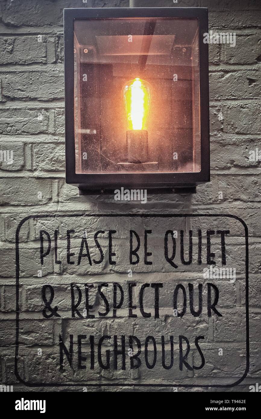 Sign on a pub wall reading 'Please be quiet and respect our neighbours ...